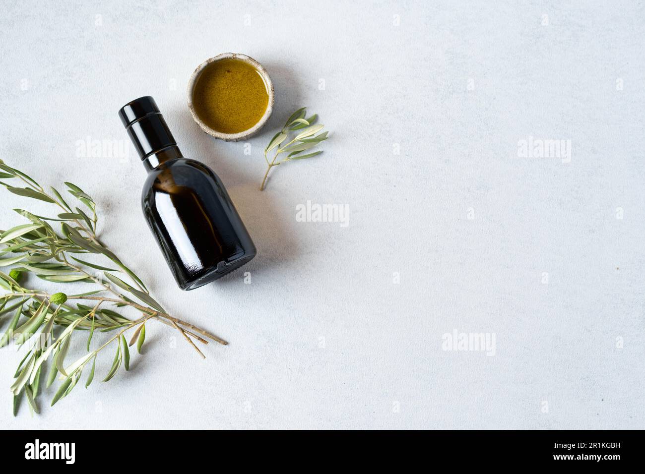Homemade organic olive oil in a black glass bottle. A sprig of the ...