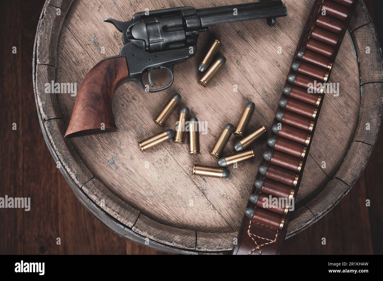 Old west gun with belt, holster and ammunition on wooden barrel Stock ...
