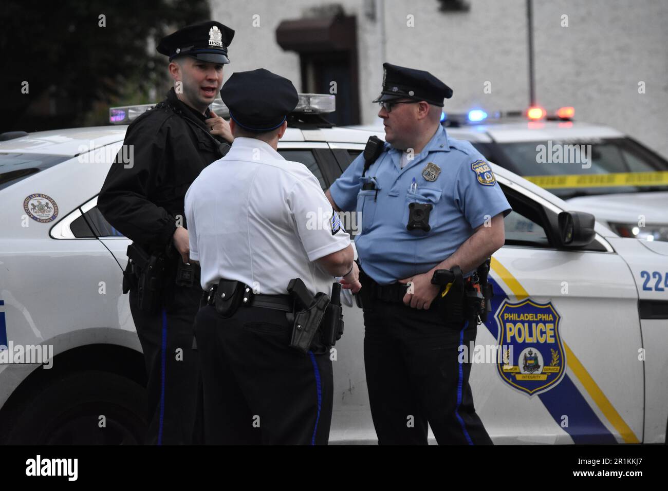 Multiple police officers gather evidence and converse at the crime ...