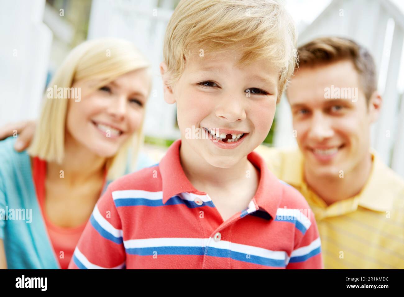 Hes so well-adjusted. Happy young family sitting together outdoors ...