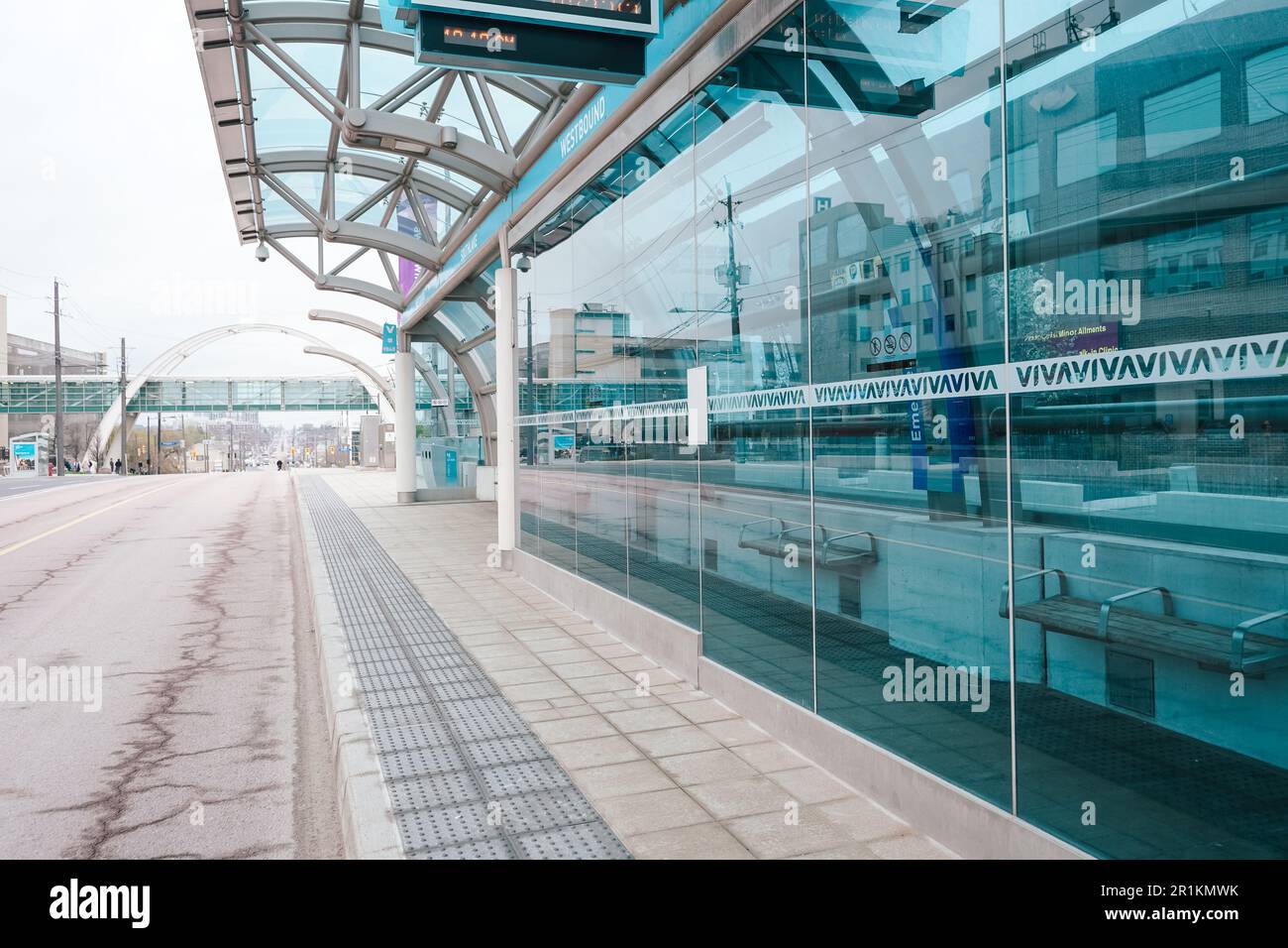 An outdoor bus shelter, features curved tubular steel trusswork ...