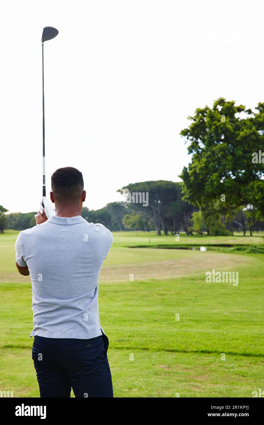 All about the follow through. Rear view shot of a young man who has ...