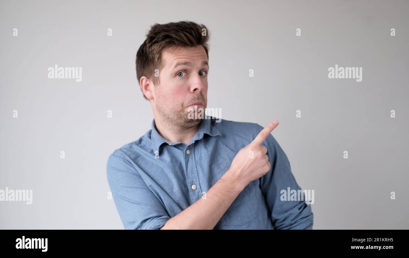 young man points with his index finger towards an empty space for your ...
