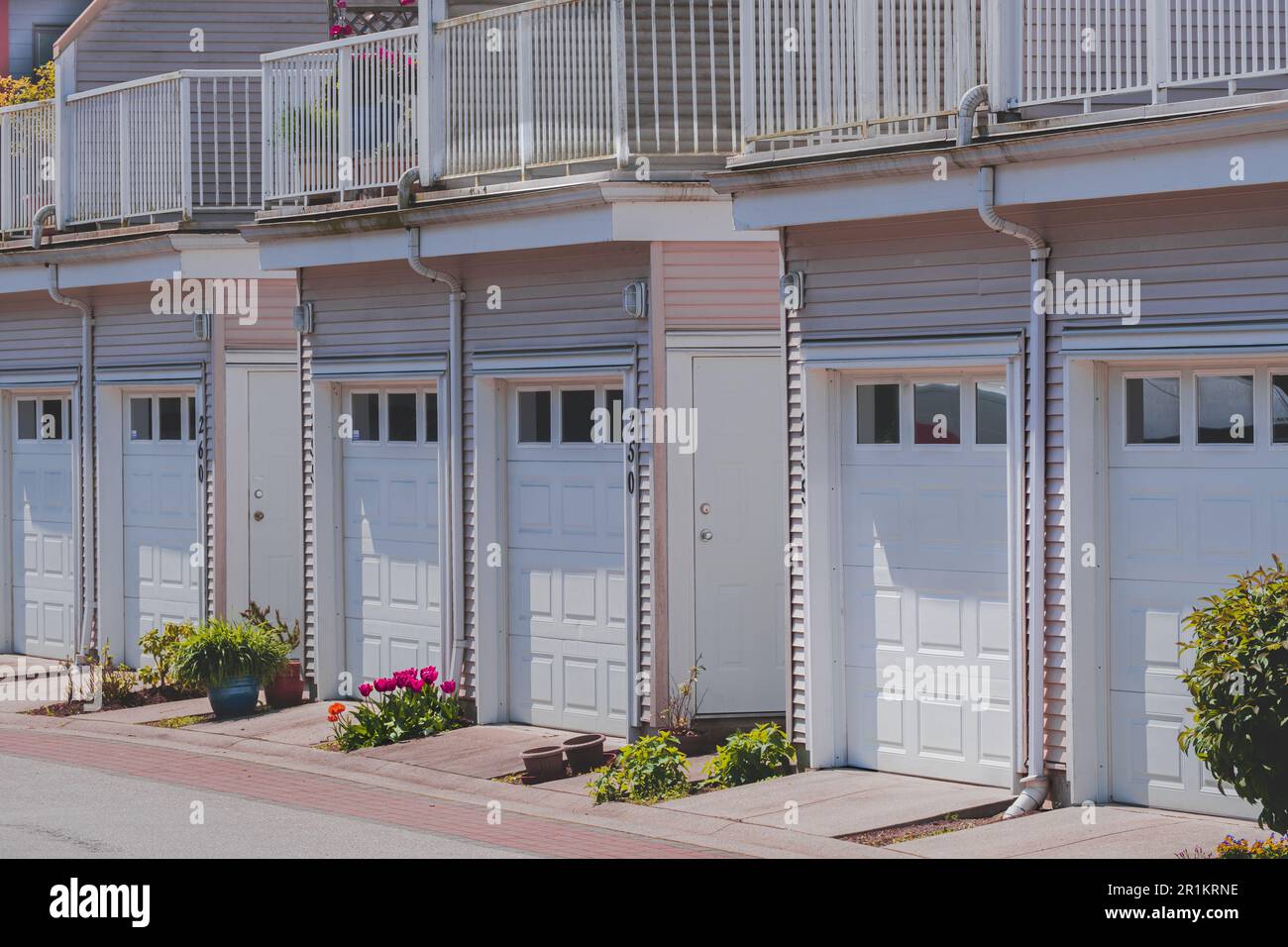 Garage door with short driveway. Nice neighborhood on a sunny day. Row ...