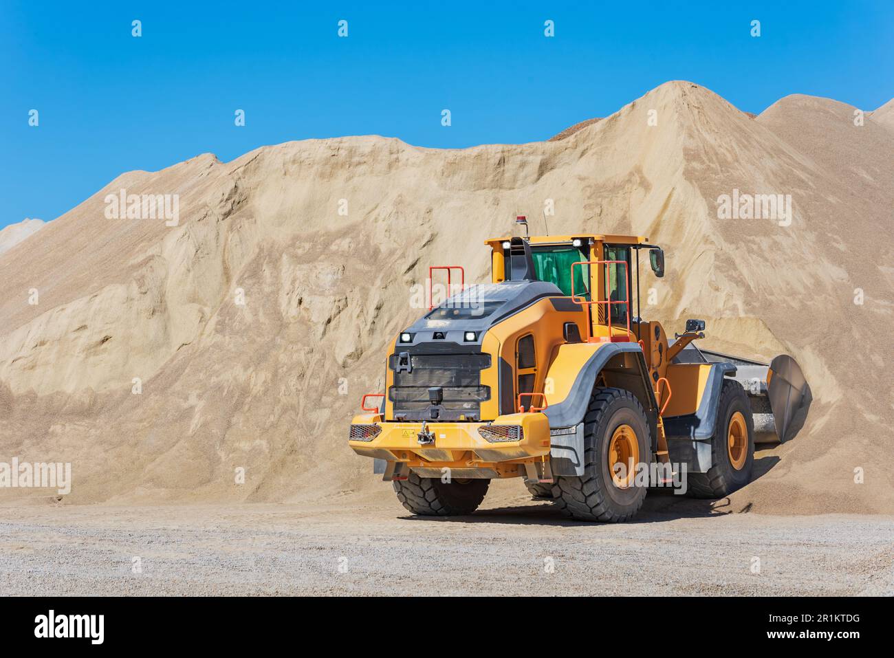 Wheel loaders moving sand in a quarry.Close-up Stock Photo - Alamy
