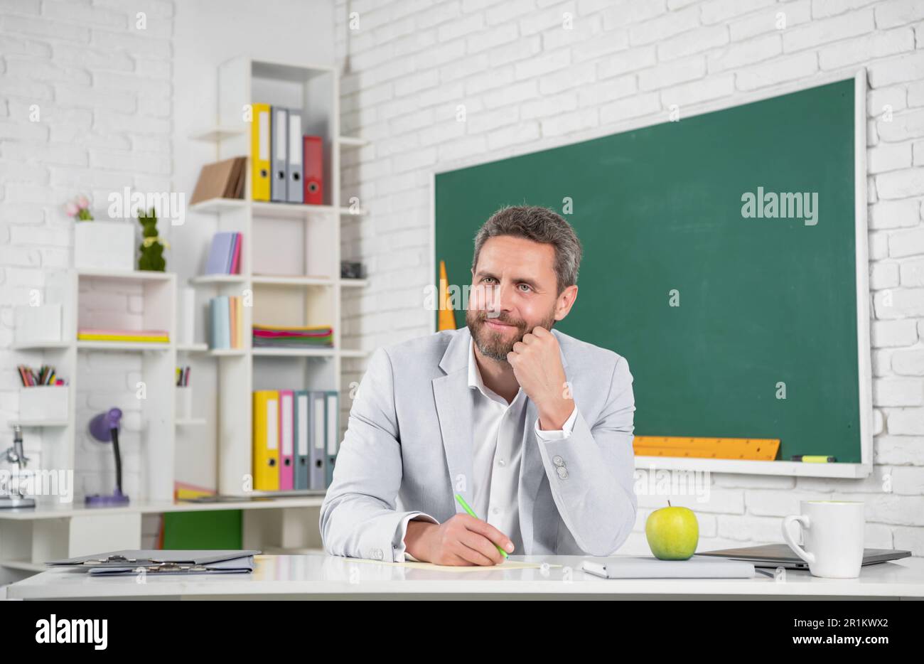 happy school tutor in classroom at blackboard Stock Photo - Alamy