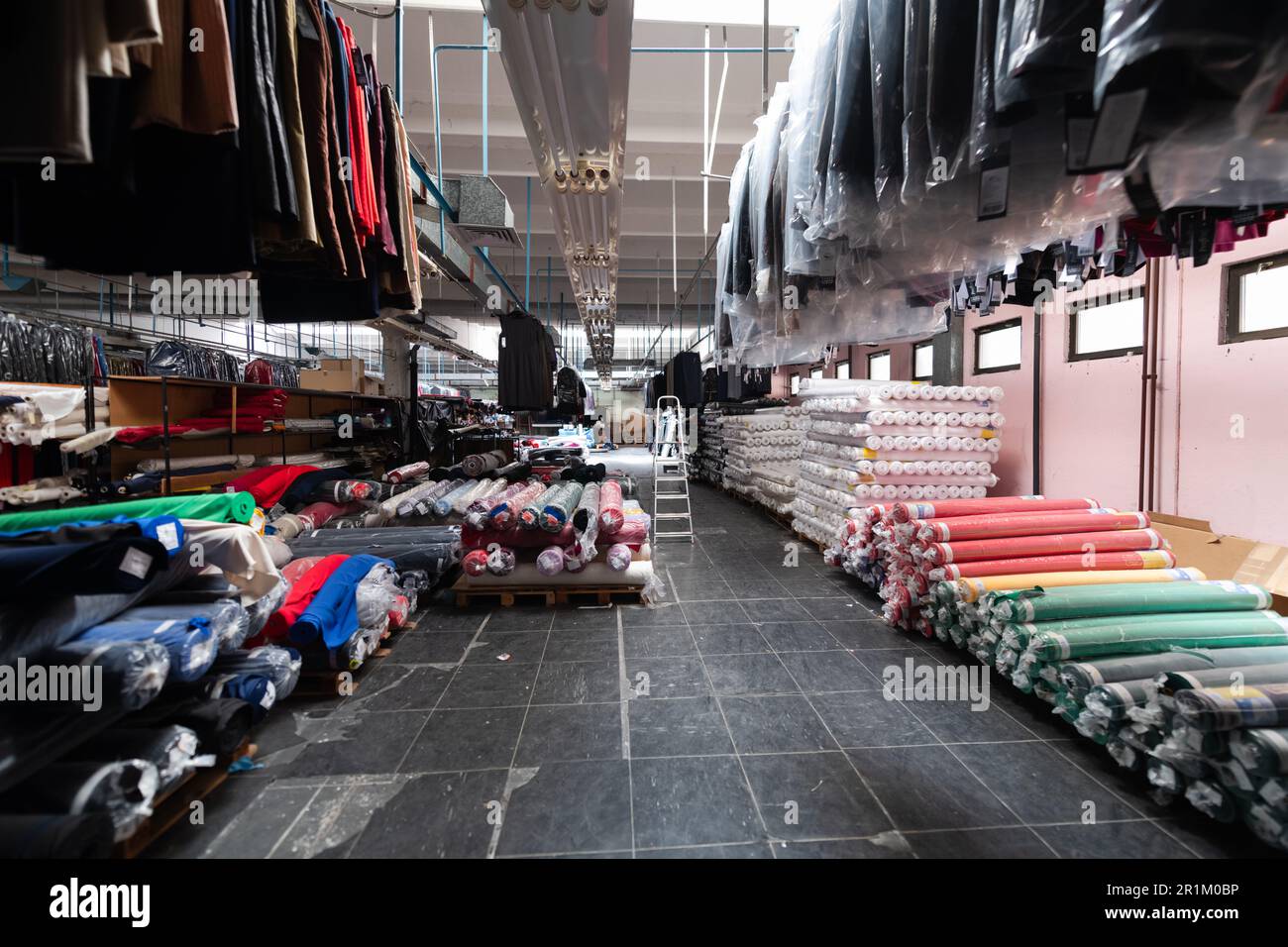 Interior of an industrial warehouse with fabric rolls samples. Small ...