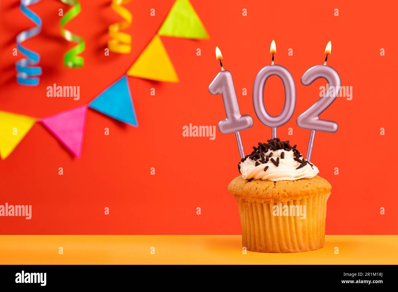 Birthday cake with number 102 candle - Sparkling orange background with ...