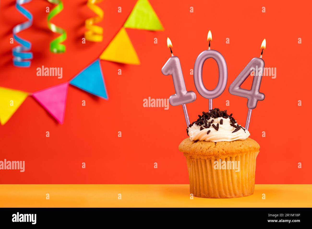 Birthday cake with number 104 candle - Sparkling orange background with ...