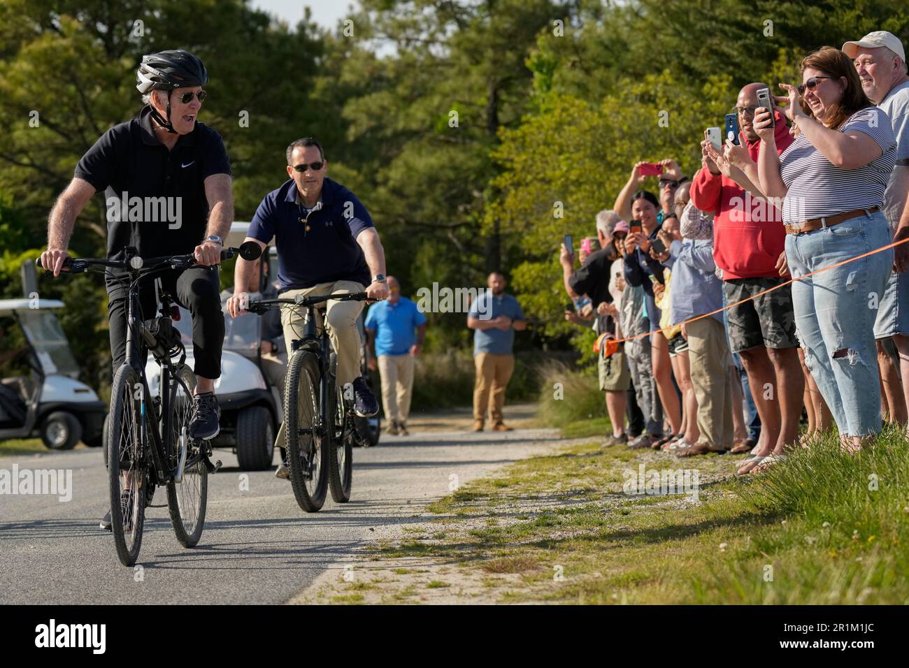 President Joe Biden looks to people gathered along the path as he goes ...