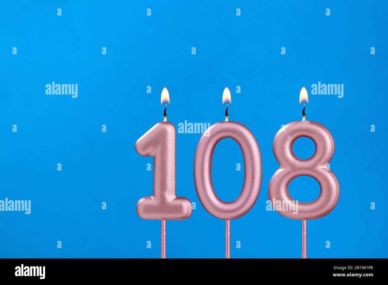 Candle number 108 - Birthday in blues foamy background Stock Photo - Alamy