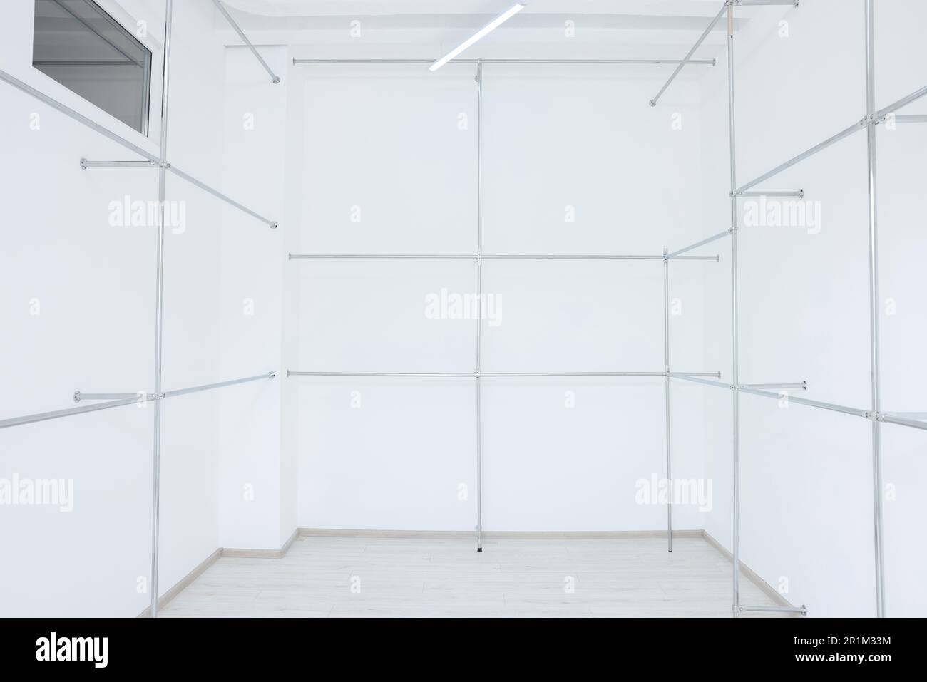 Empty room with beautiful white walls and garment racks during repair ...