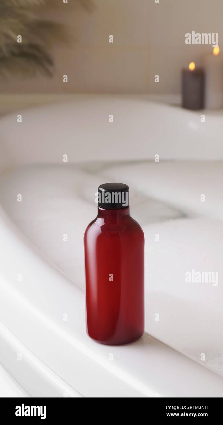 Red bottle of bubble bath on tub indoors Stock Photo - Alamy