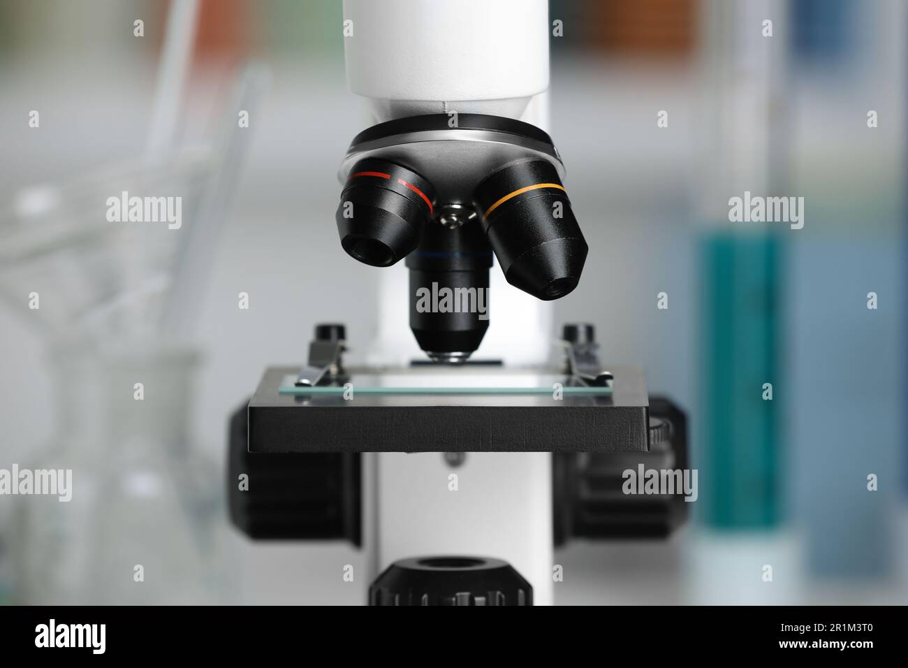 Modern medical microscope with glass slide on blurred background ...
