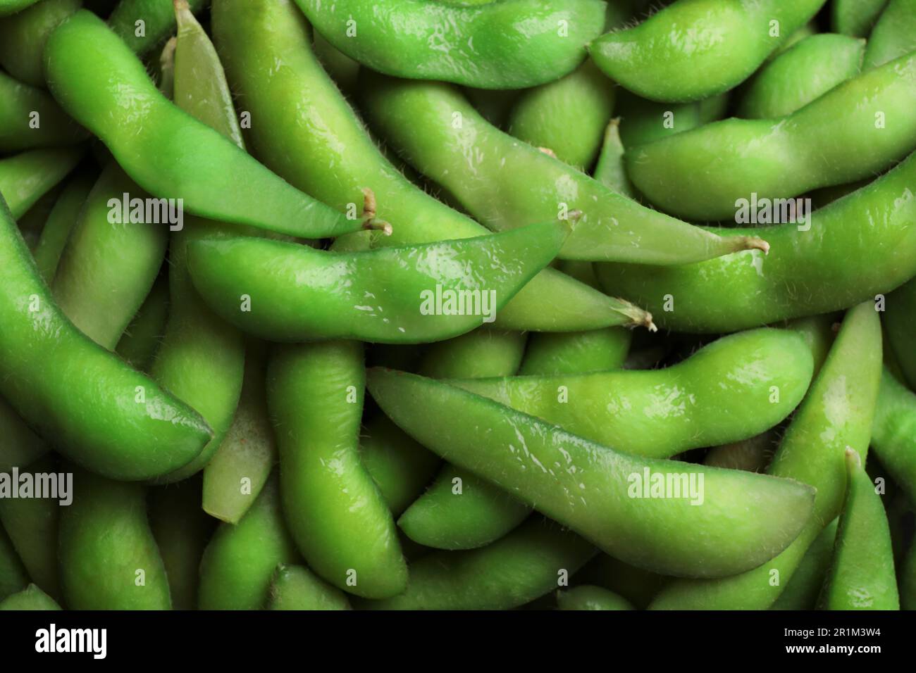 Many green edamame beans in pods as background, closeup Stock Photo - Alamy