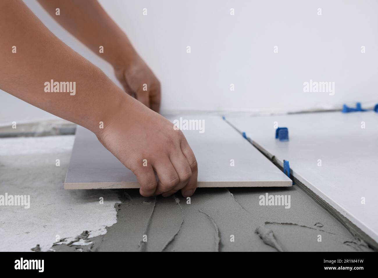 Worker installing ceramic tile on floor, closeup Stock Photo - Alamy
