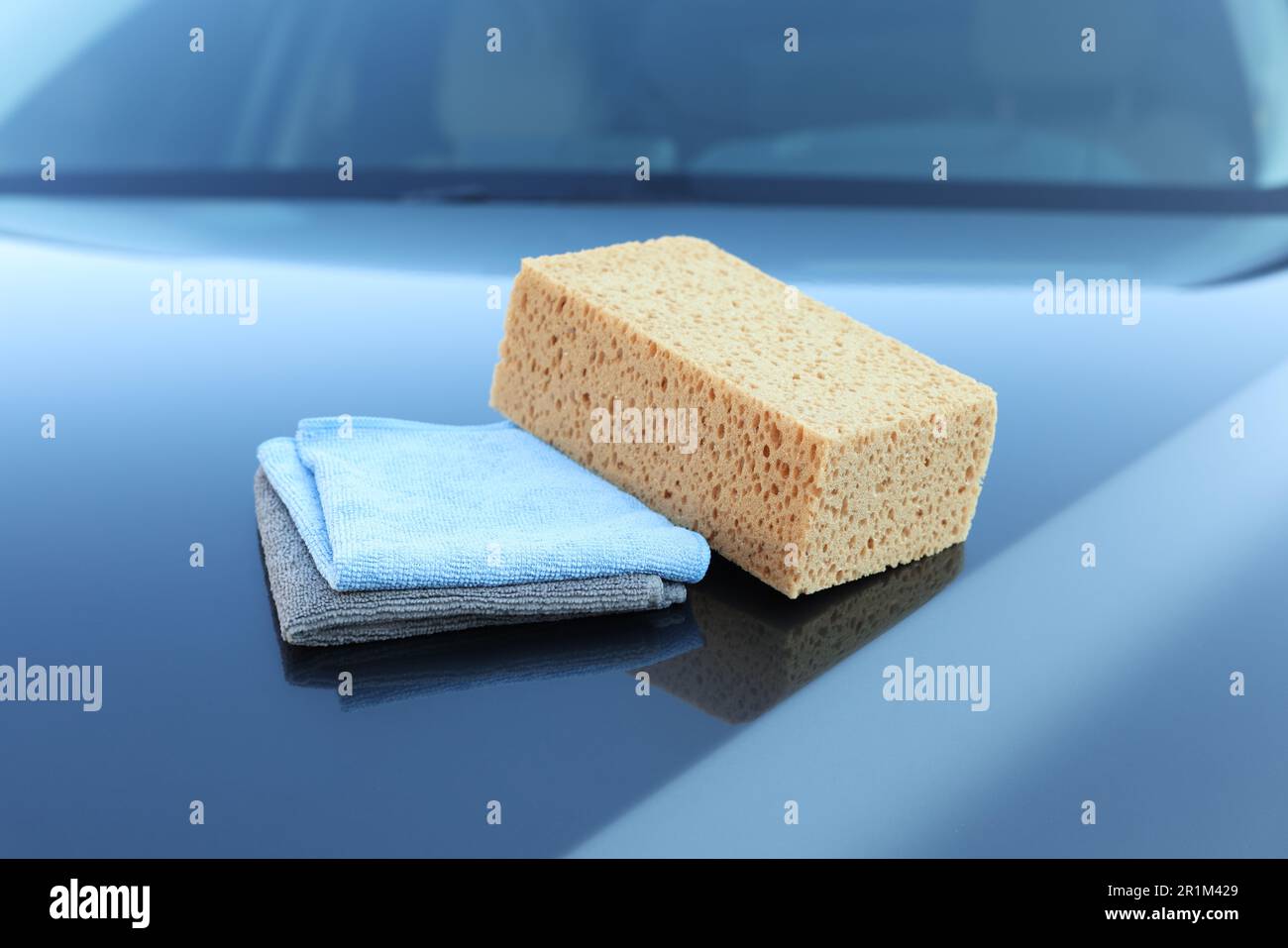 Sponge and rags on car hood. Cleaning products Stock Photo - Alamy