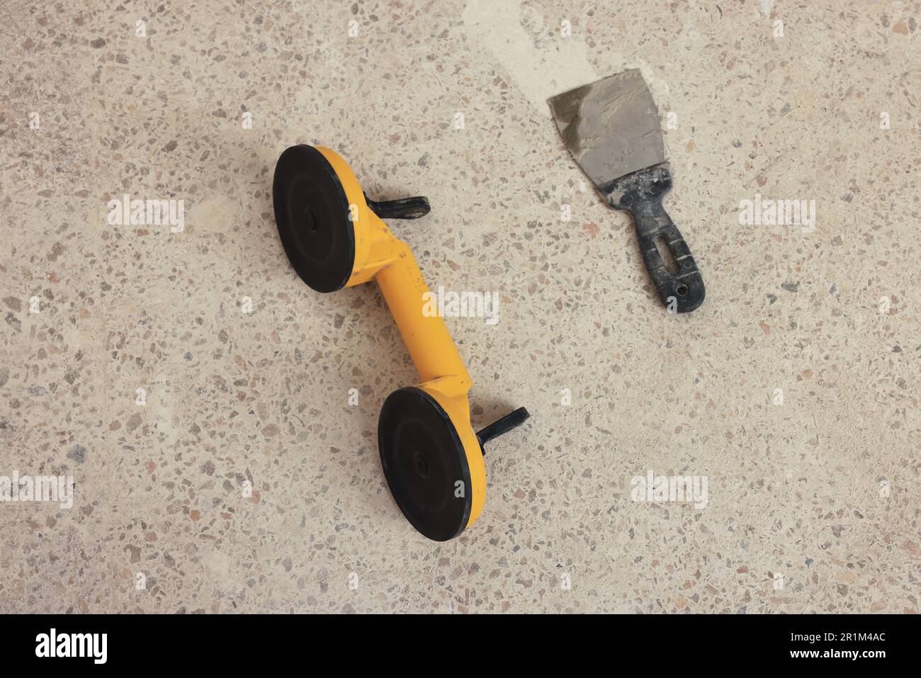 Glass suction plate and metal spatula on floor, above view. Tiles ...