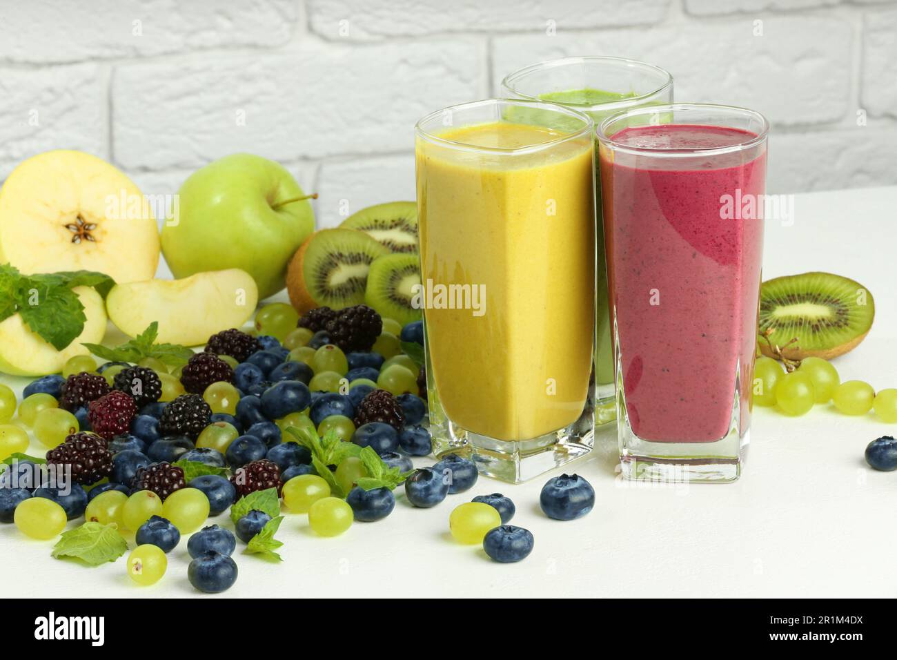 Fresh colorful fruit smoothies and ingredients on white table Stock ...
