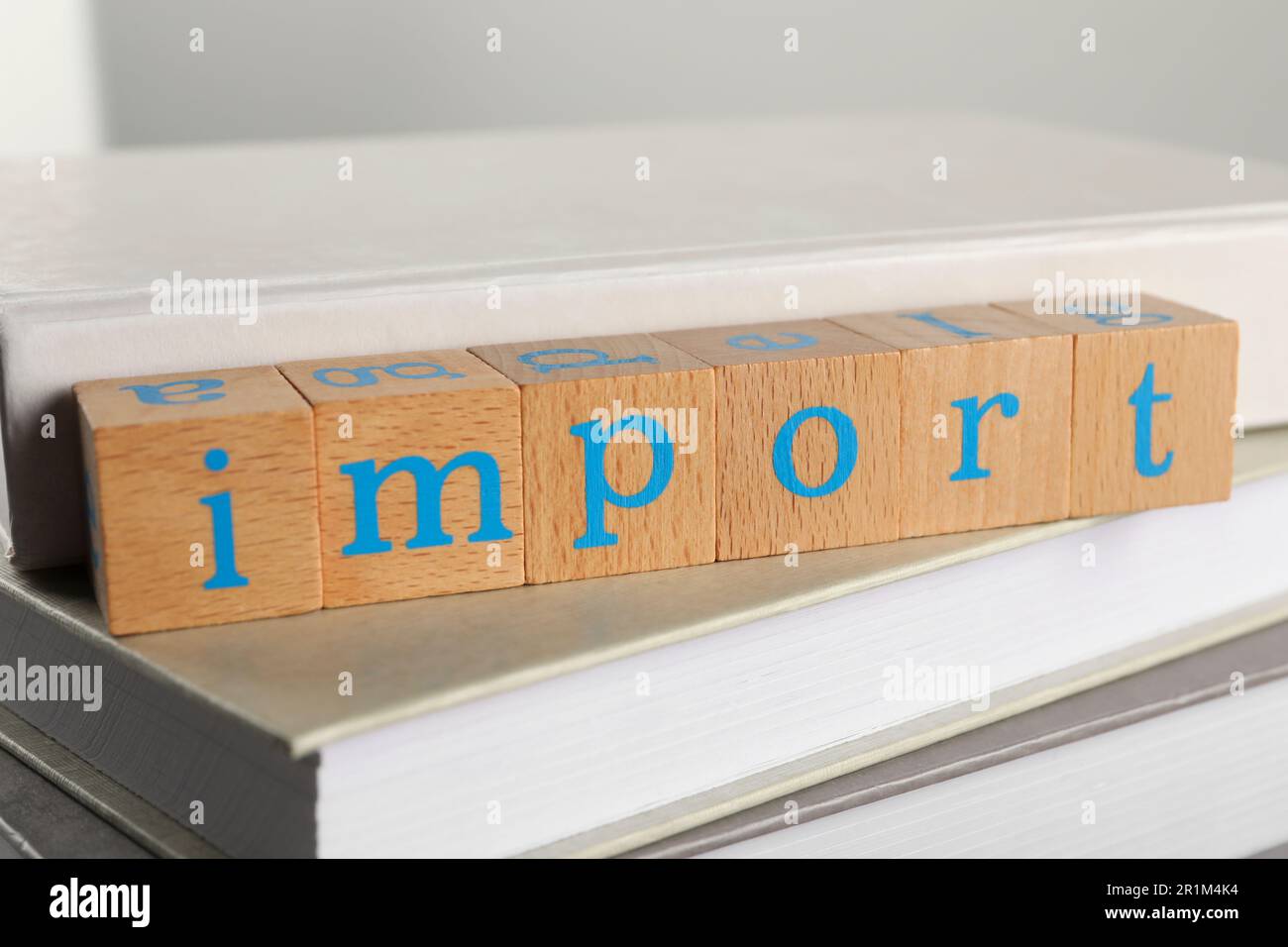 Word Import made of wooden cubes on books, closeup Stock Photo - Alamy