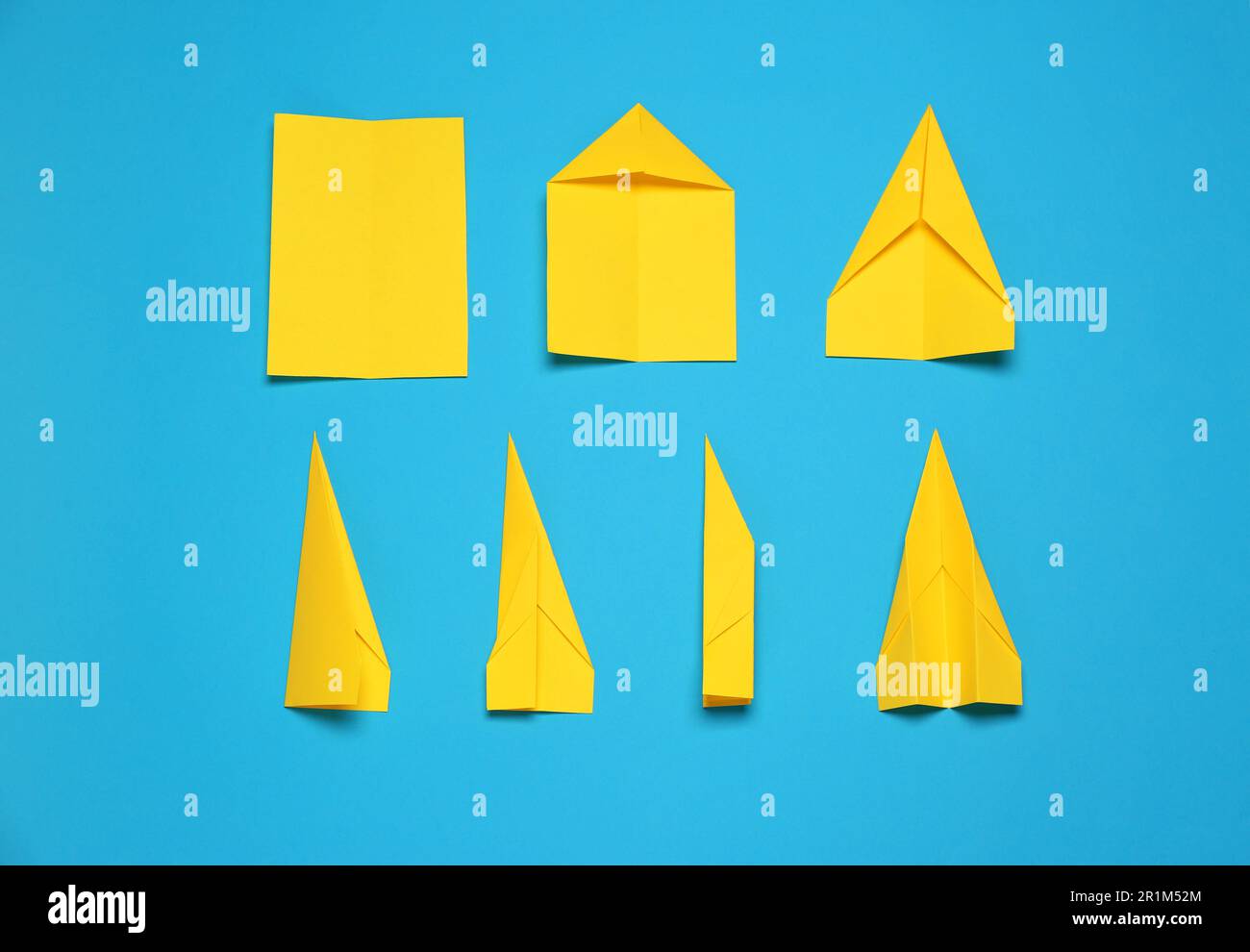 Making paper plane step by step. Instruction on light blue background ...