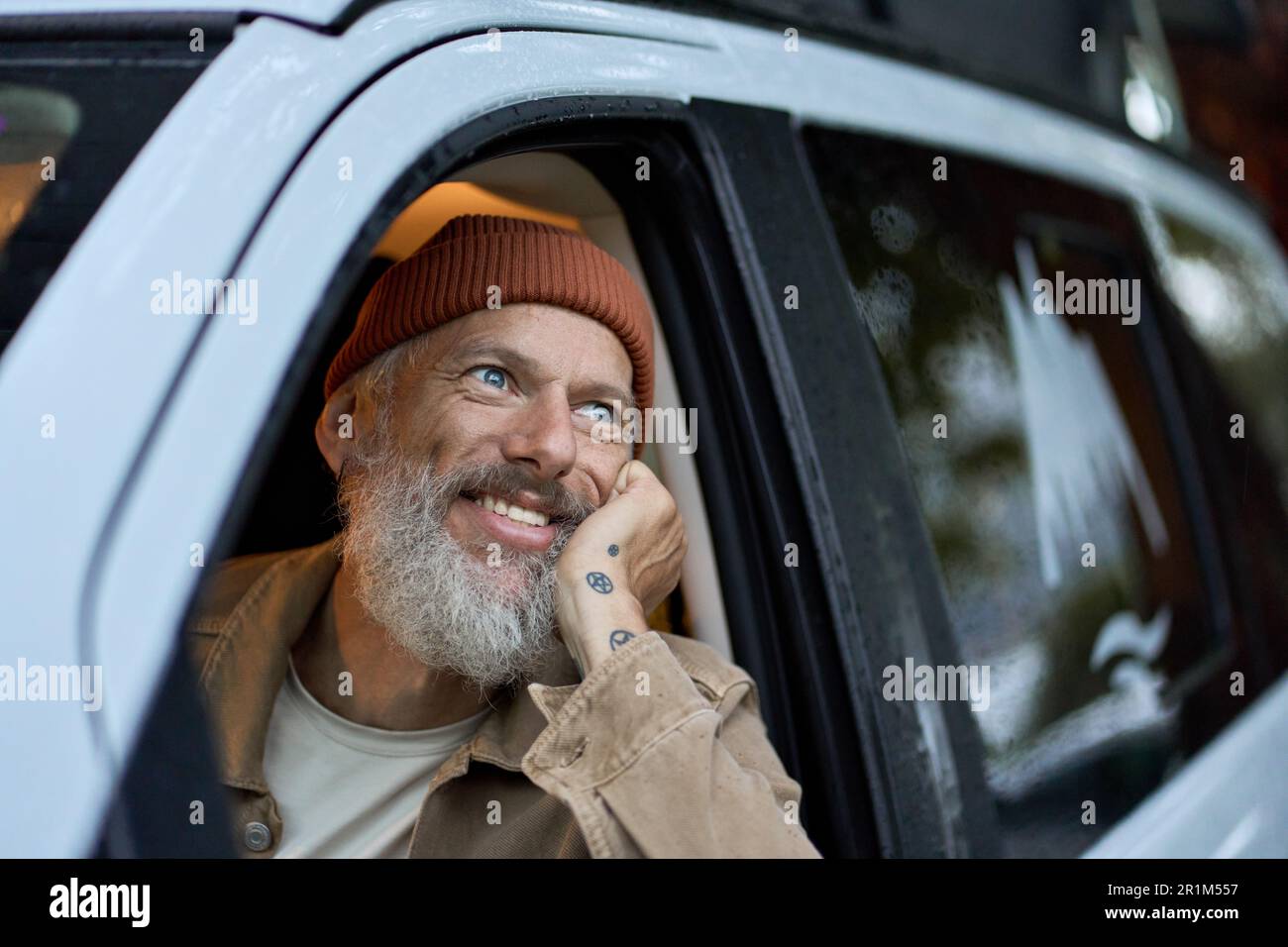 Excited happy older man driving rv camper van looking outside enjoying ...