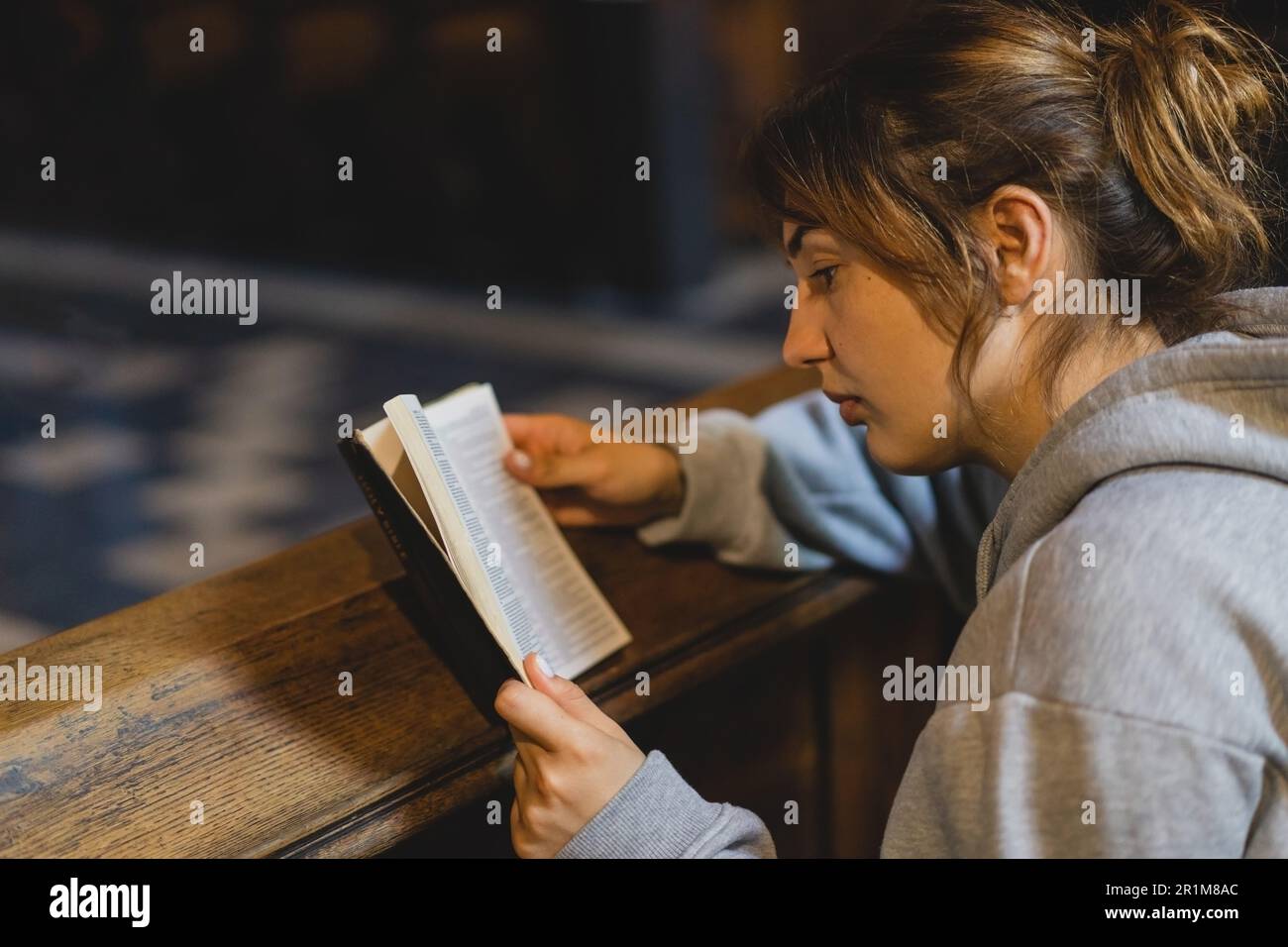 Christian woman reading bible in an ancient Catholic temple. Reading ...