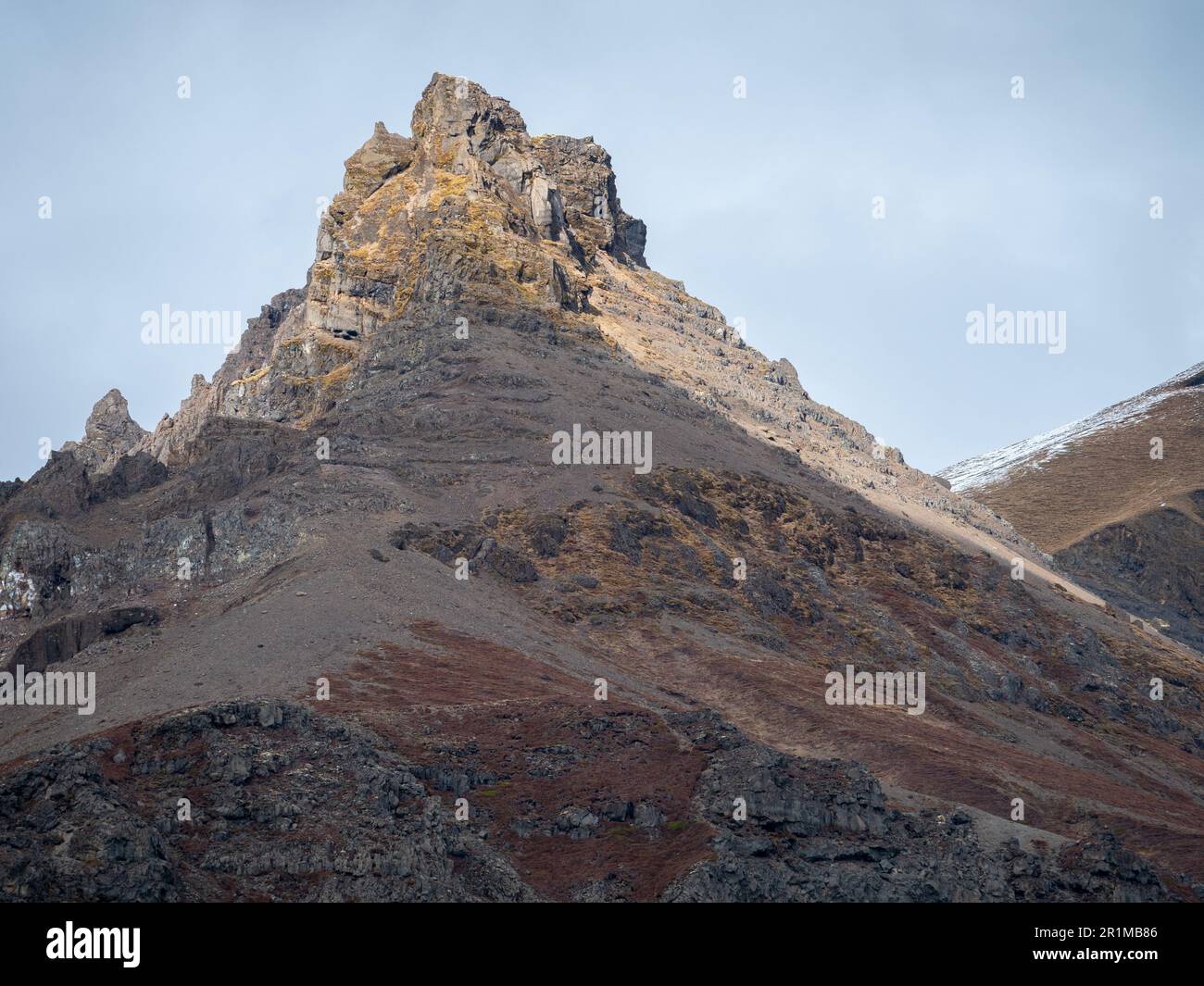 A close-up shot of a rocky hill with a unique rock face at the top ...
