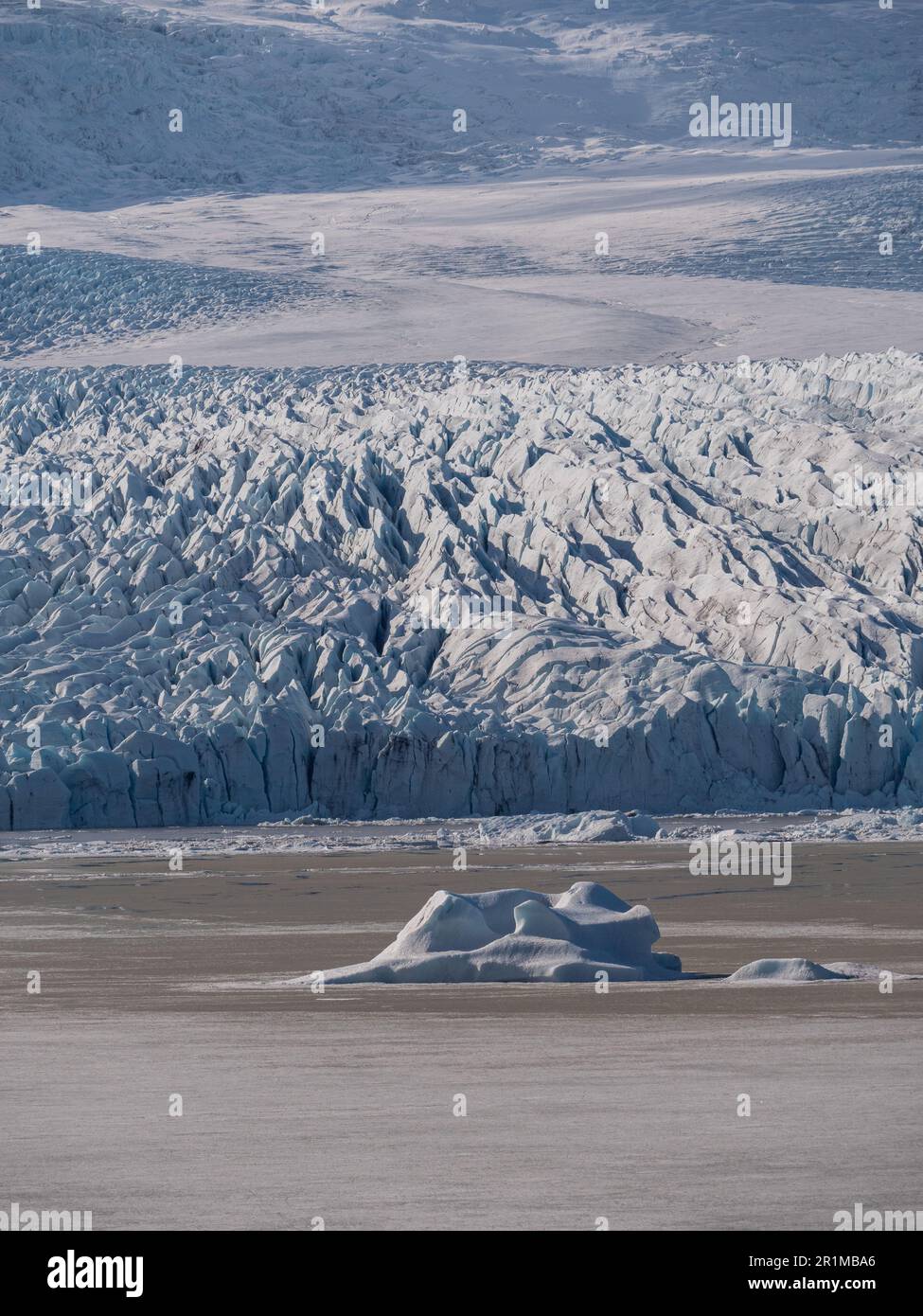 A picturesque landscape of an iceberg in the water with a backdrop of ...