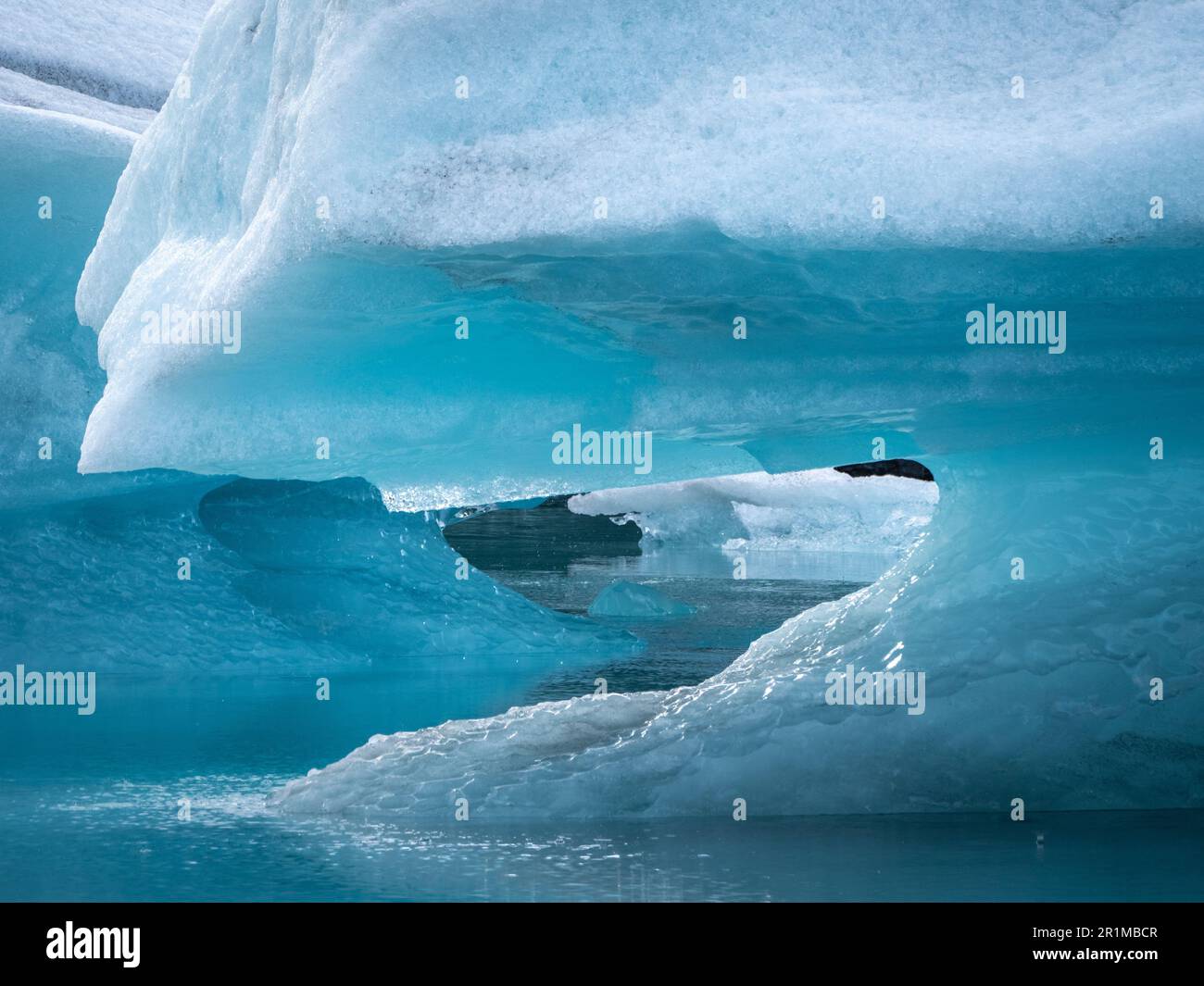 A picturesque landscape of an iceberg in the water with a backdrop of ...