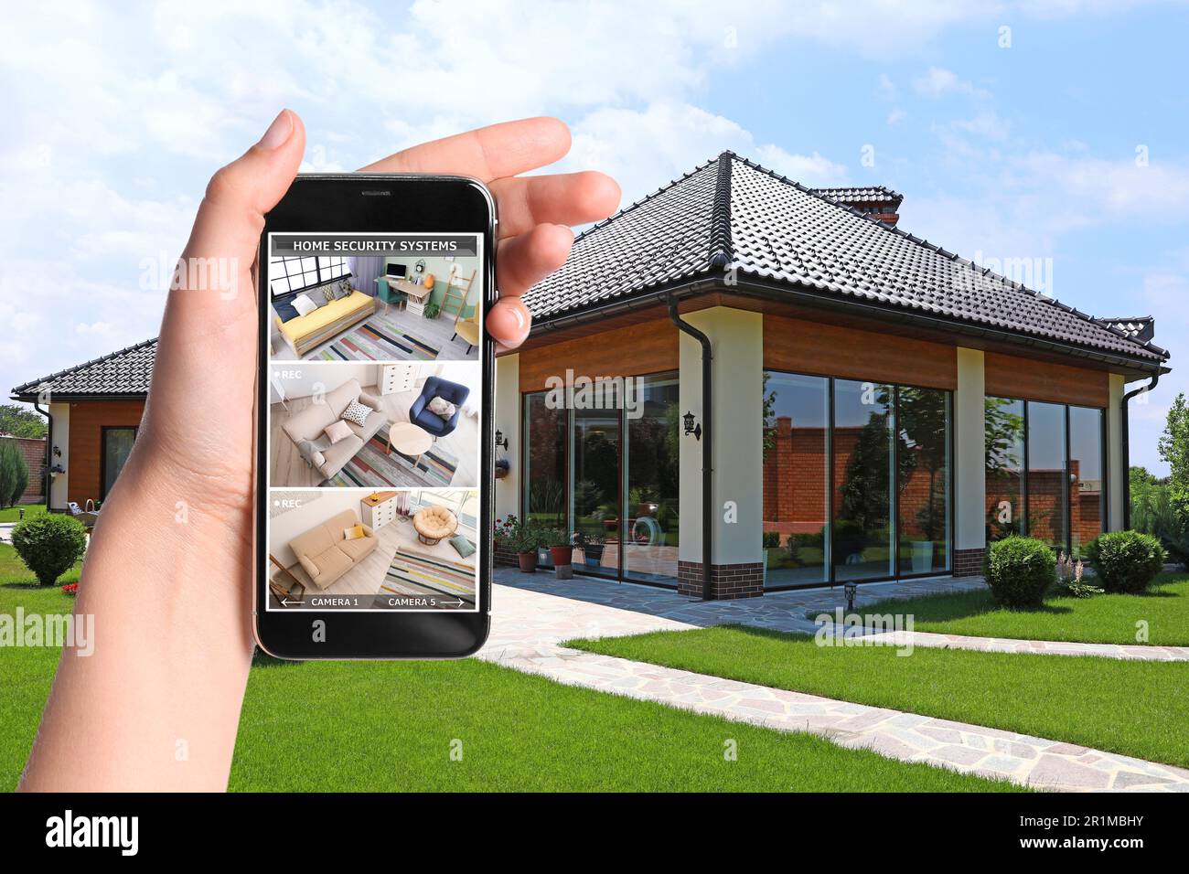 Home security system. Woman monitoring CCTV cameras on smartphone near ...