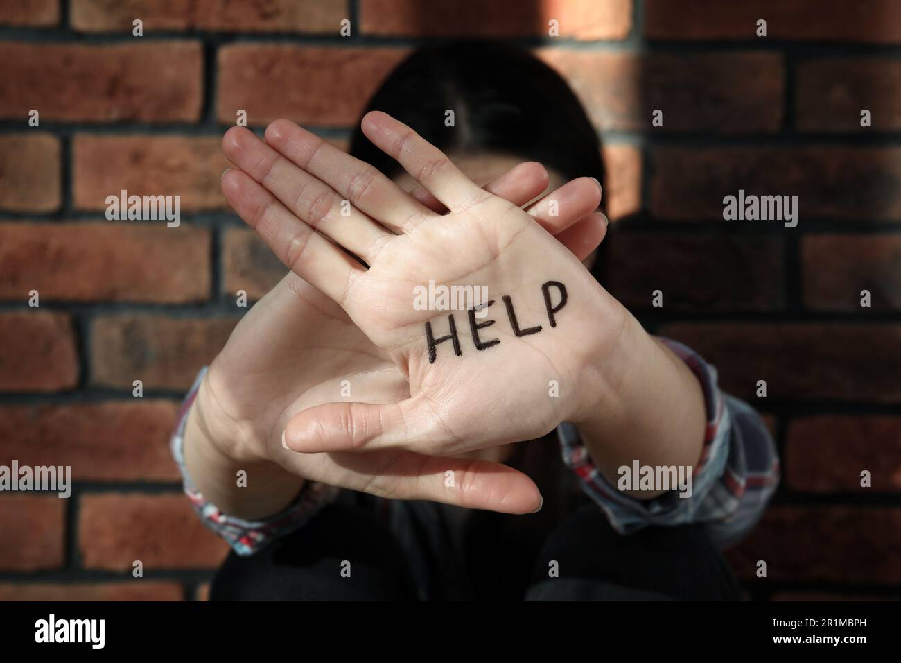 Domestic violence concept. Woman hiding her face, focus on hands with ...