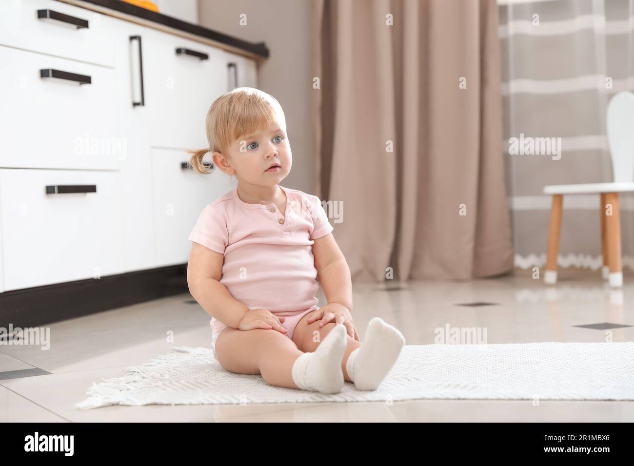 Cute little child sitting on floor at home Stock Photo - Alamy
