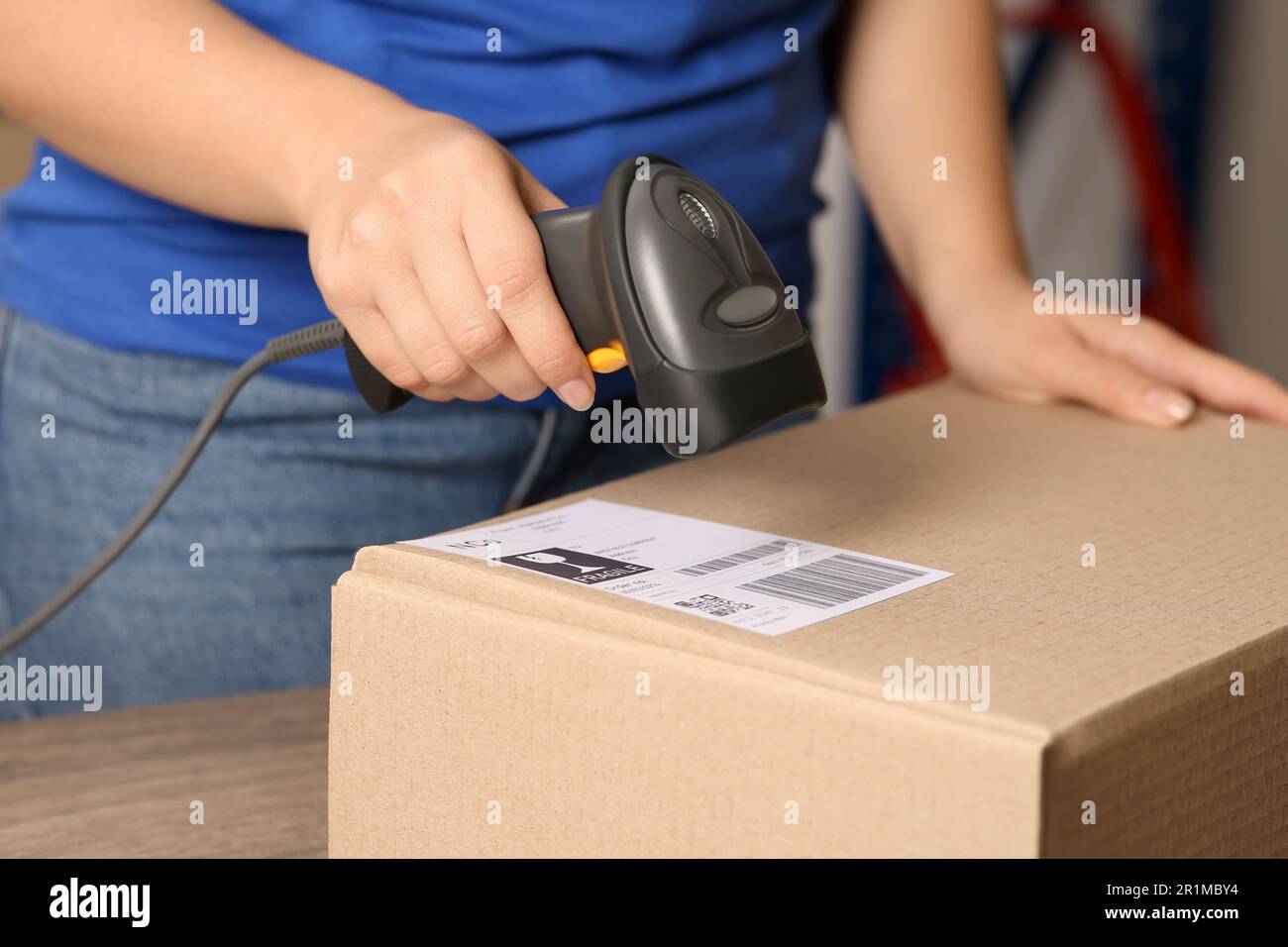Post office worker with scanner reading parcel barcode at counter ...
