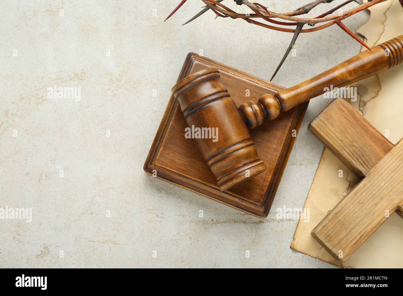 Judge gavel and wooden cross on light grey table, flat lay. Space for ...
