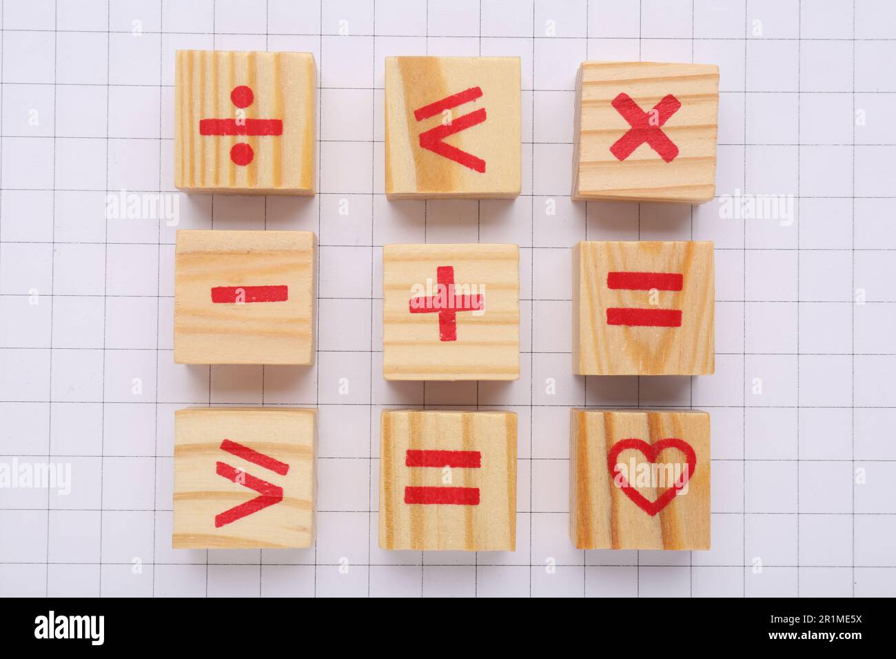 Wooden cubes with mathematical symbols and heart on sheet of grid paper ...