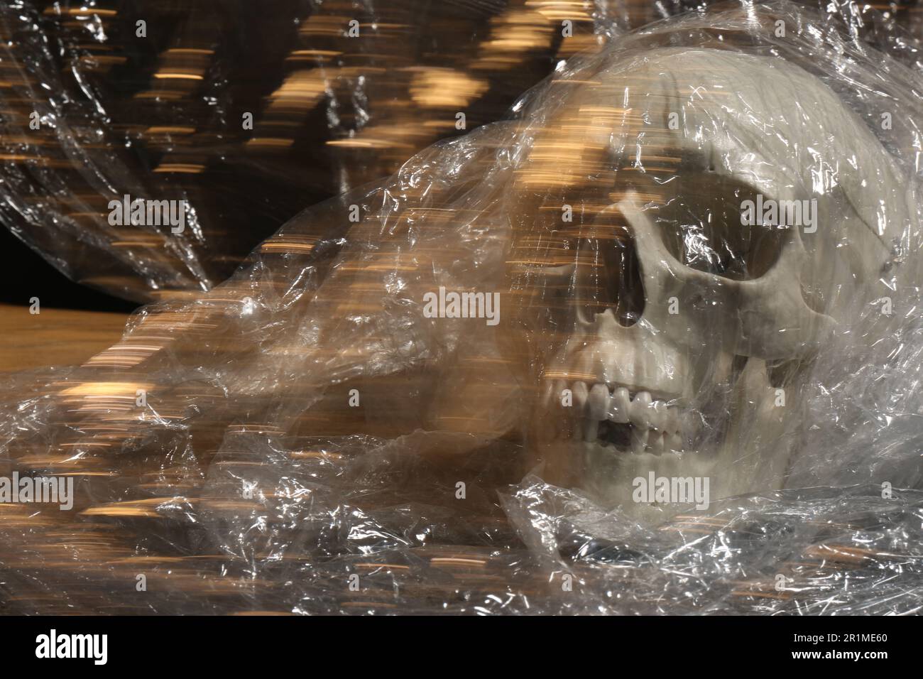 Human skull with stretch film on blurred background Stock Photo - Alamy