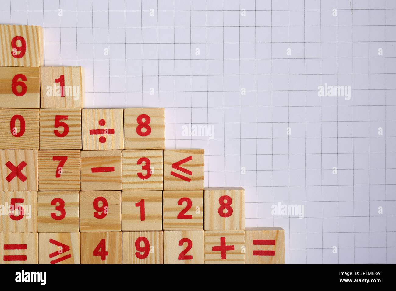 Wooden cubes with mathematical symbols and numbers on sheet of grid ...