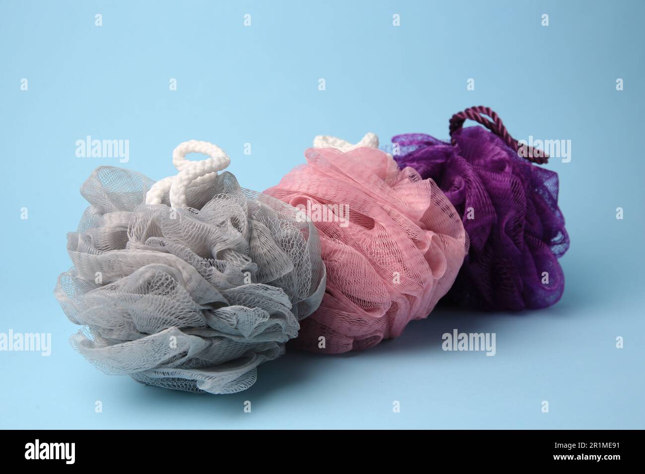 Colorful shower puffs on light blue background Stock Photo - Alamy