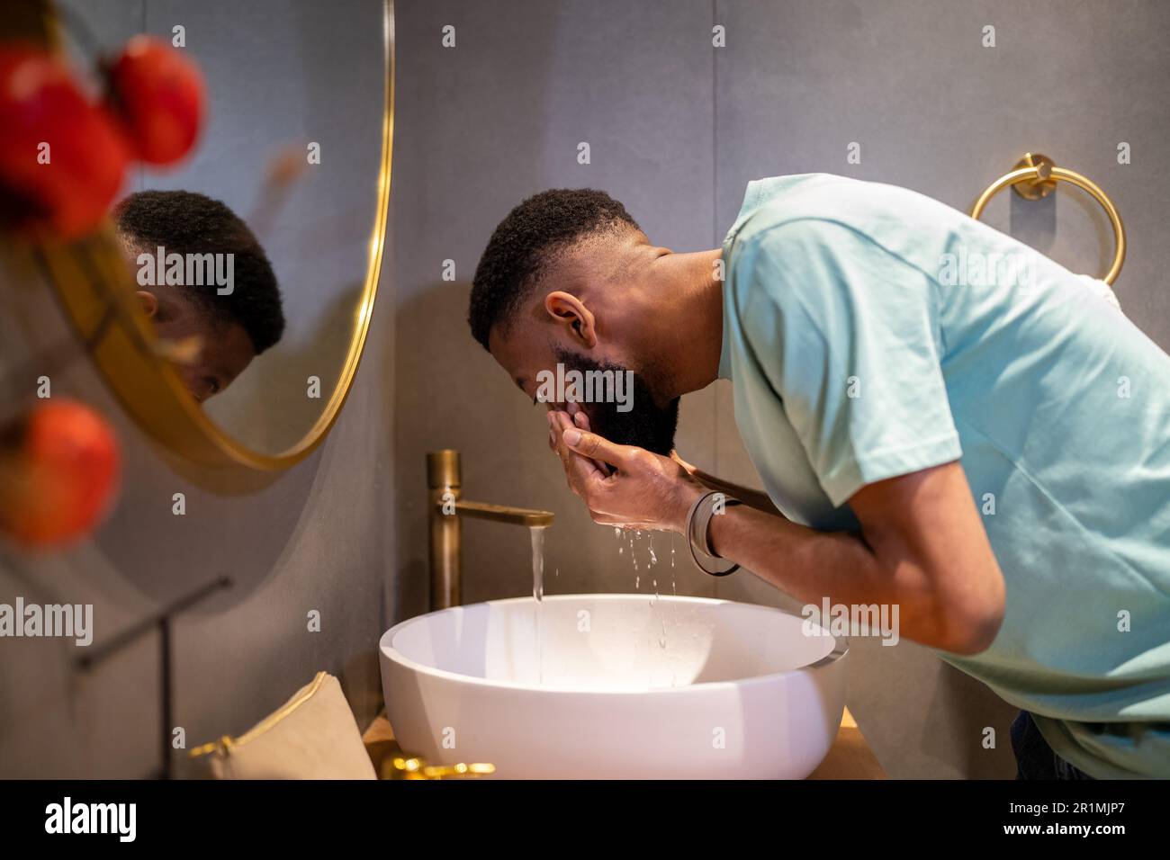 African American millennial guy cleaning skin in morning, washing face ...
