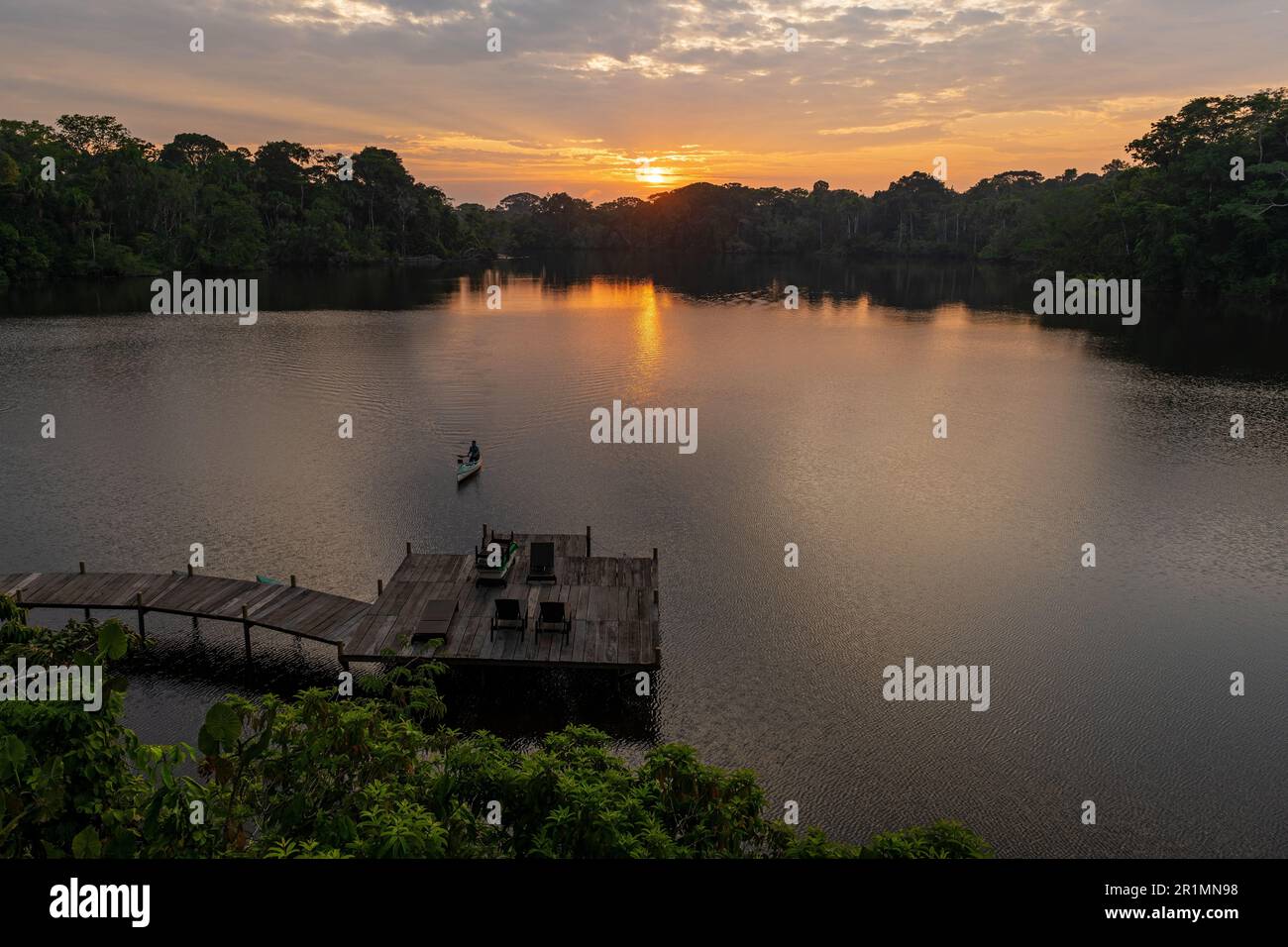 Amazon rainforest sunrise and indigenous kichwa man in canoe by Napo ...