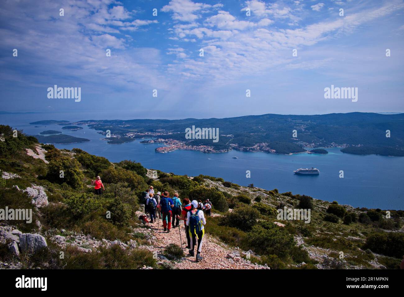 Group of people hiking down the mountain with Adriatic sea and islands ...