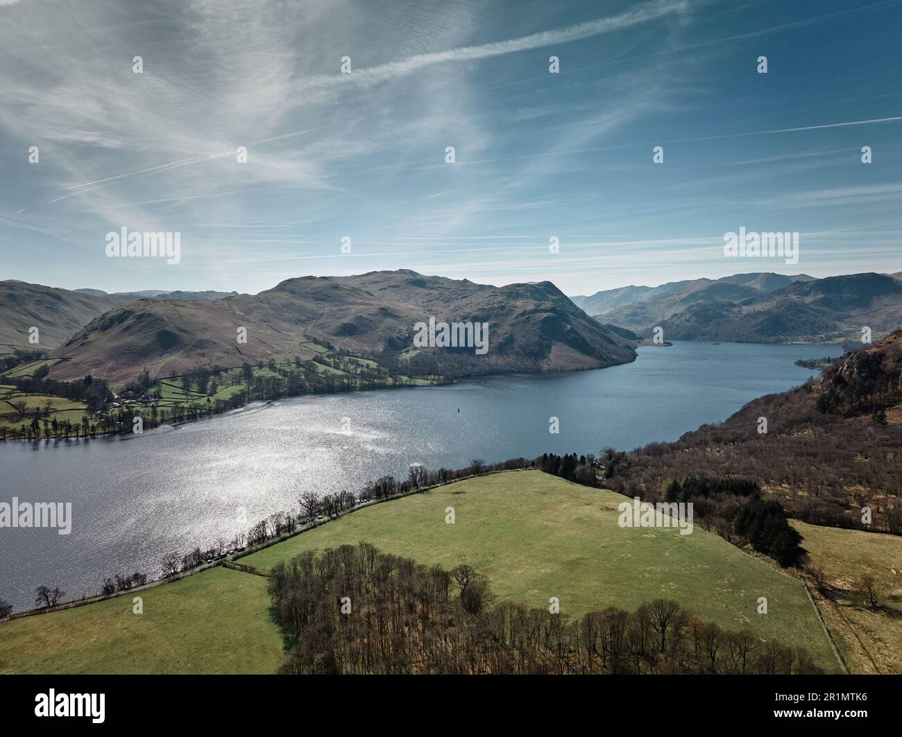 A scenic aerial view of Lake Ullswater with lush green grass ...