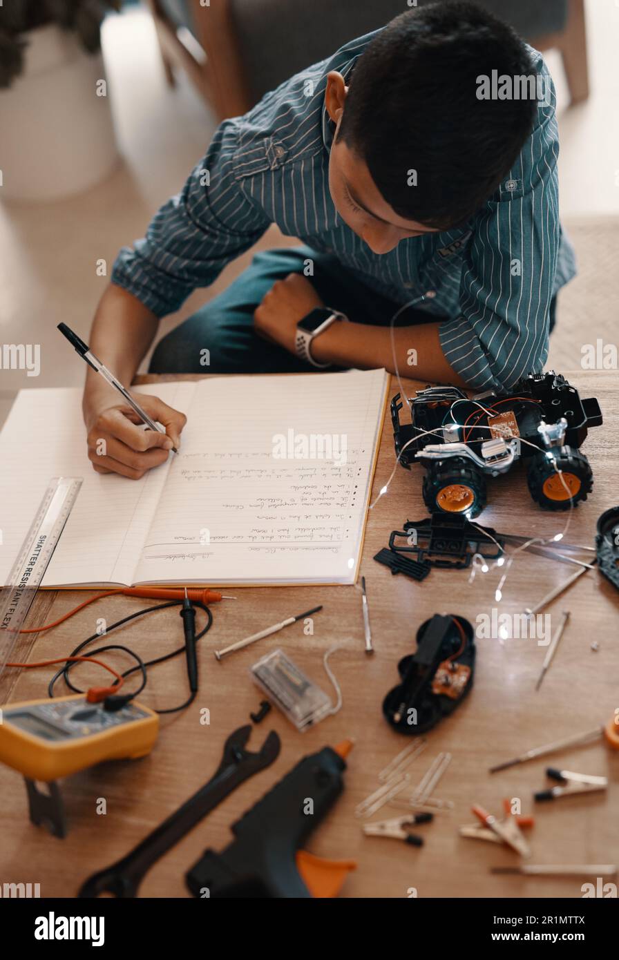 Education, writing in notebook and kid with robotics homework ...
