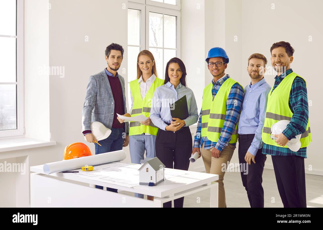 Engineers and architects standing on a building site with architectural ...