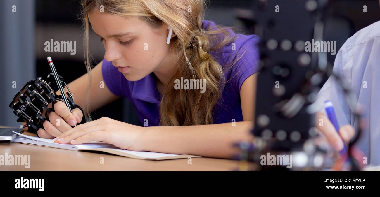Caucasian two teenager students learning robotic arm in classroom ...