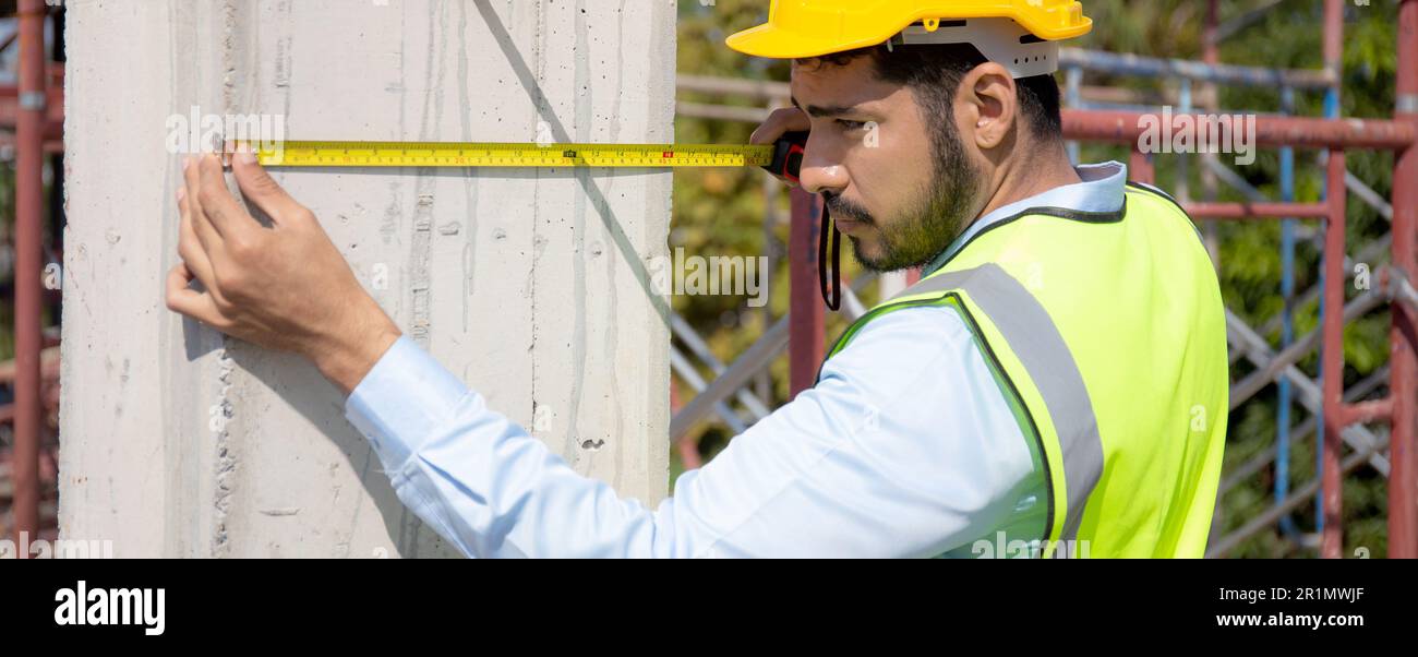 Engineer young man using tape measure for check and examining length of ...