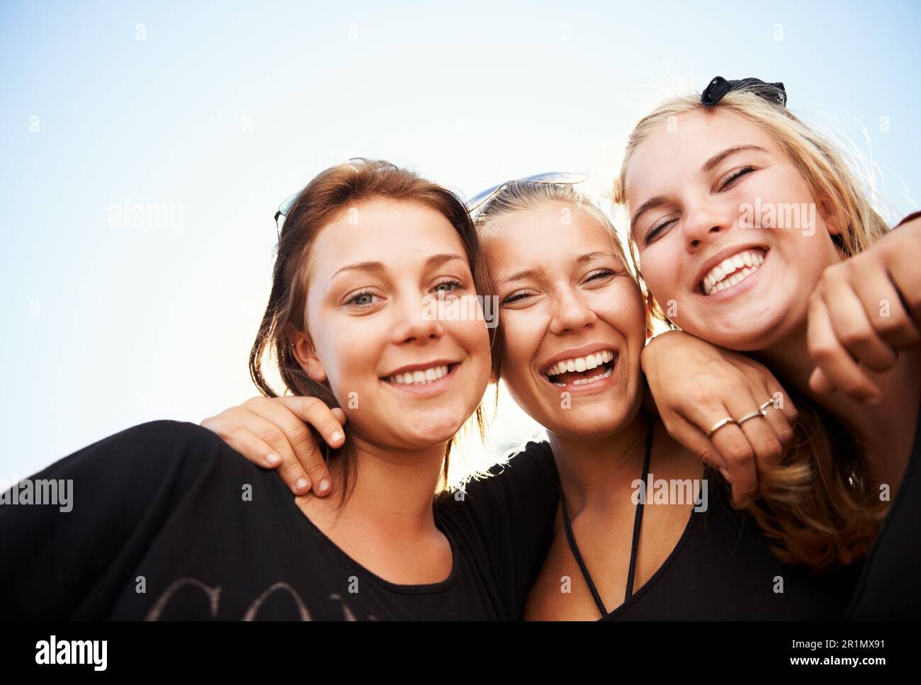 Laughter and happiness. Three friends hugging and smiling against a ...