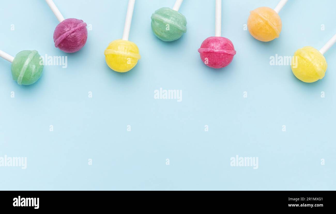 Colorful sweet lollipops and candies over blue background. Flat lay ...