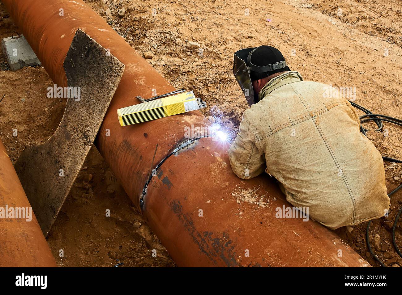 The welder welds the pipe by electro welding Stock Photo - Alamy